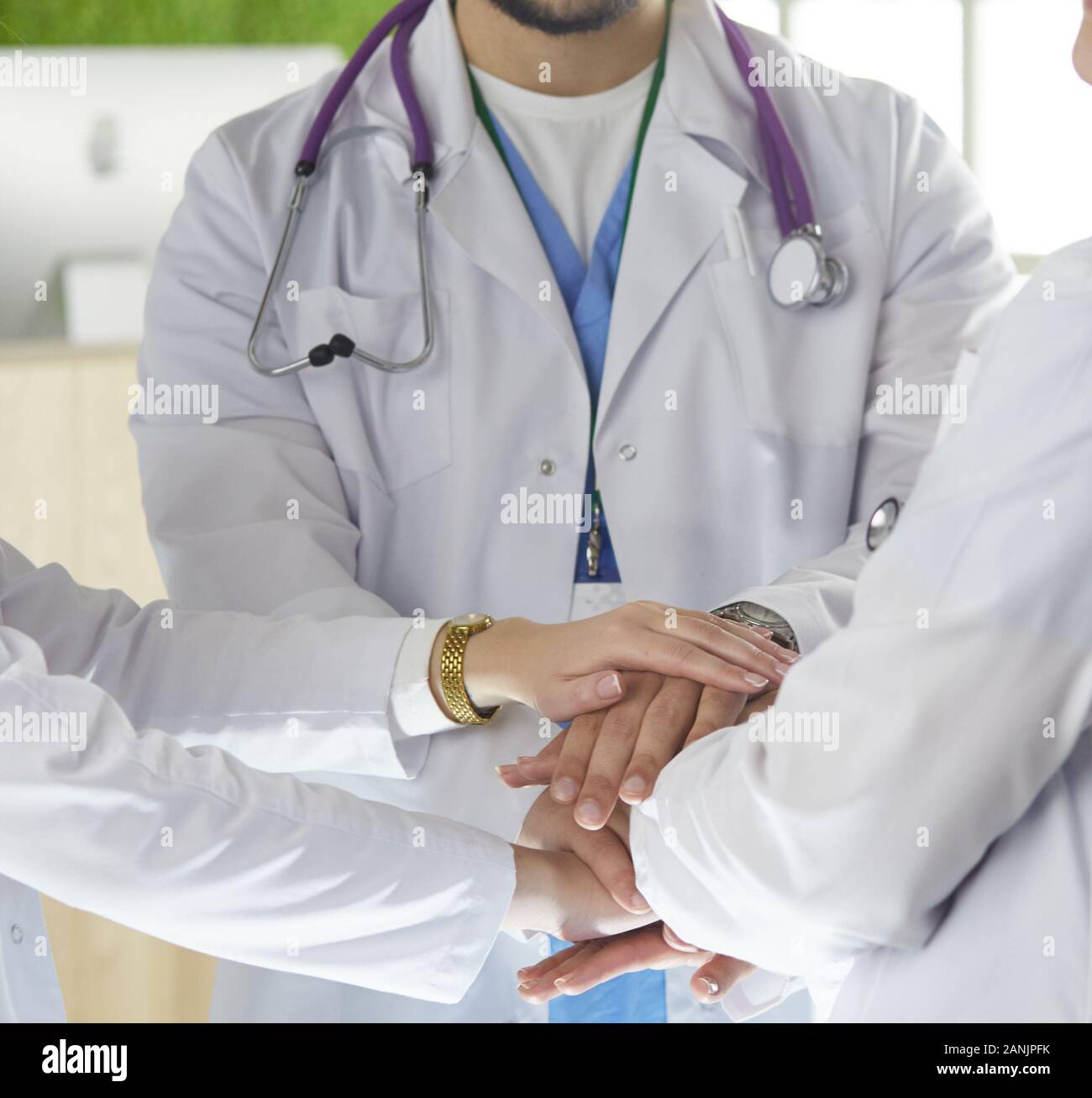 Team of medical workers holding hands together indoors, above view. Unity concept Stock Photo ...