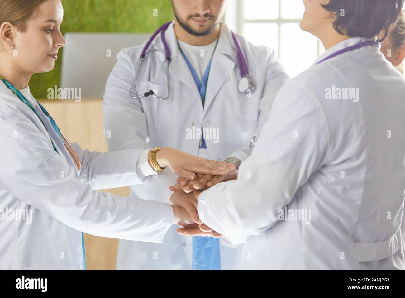 Team of medical workers holding hands together indoors, above view. Unity concept Stock Photo ...
