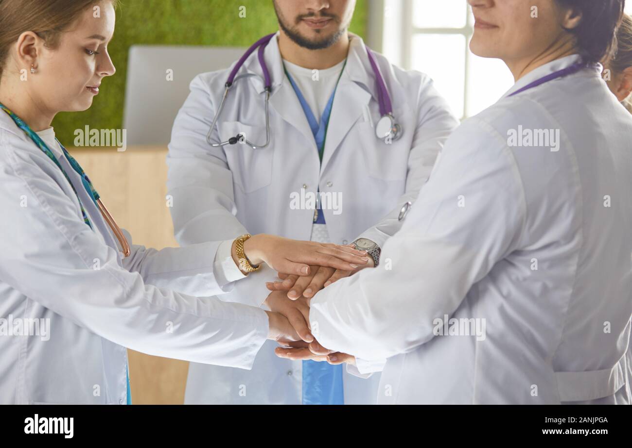 Team of medical workers holding hands together indoors, above view. Unity concept Stock Photo ...