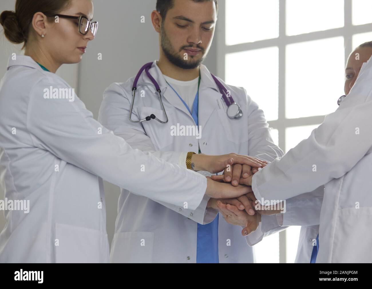 Team of medical workers holding hands together indoors, above view. Unity concept Stock Photo ...
