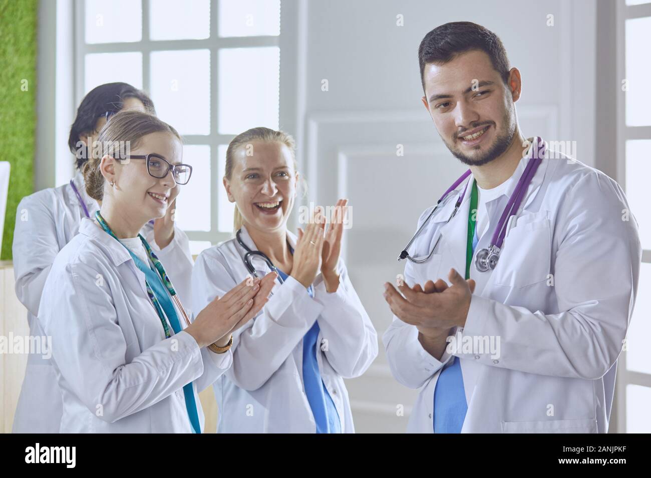 Happy medical team comprising male and female doctors smiling broadly ...