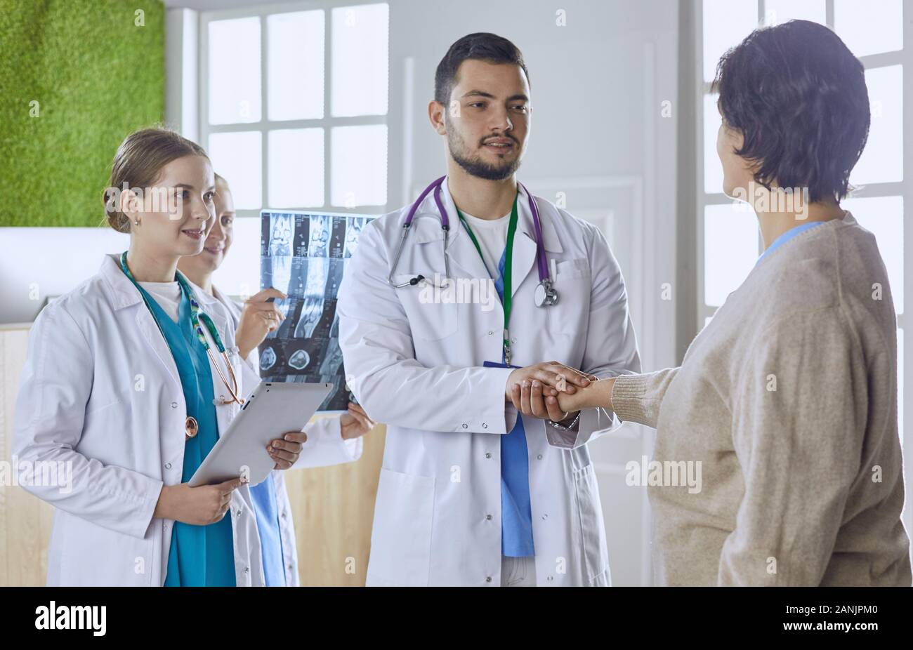Patient with a group of doctors at the background Stock Photo - Alamy