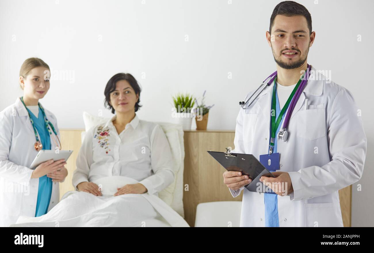 Patient with a group of doctors at the background Stock Photo - Alamy