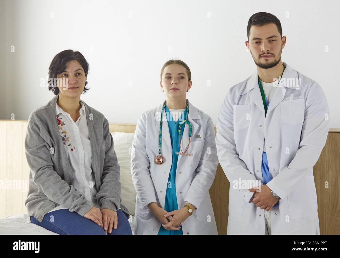Patient with a group of doctors at the background Stock Photo - Alamy