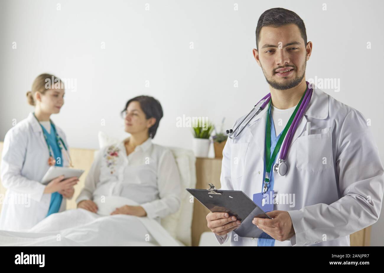 Patient with a group of doctors at the background Stock Photo - Alamy