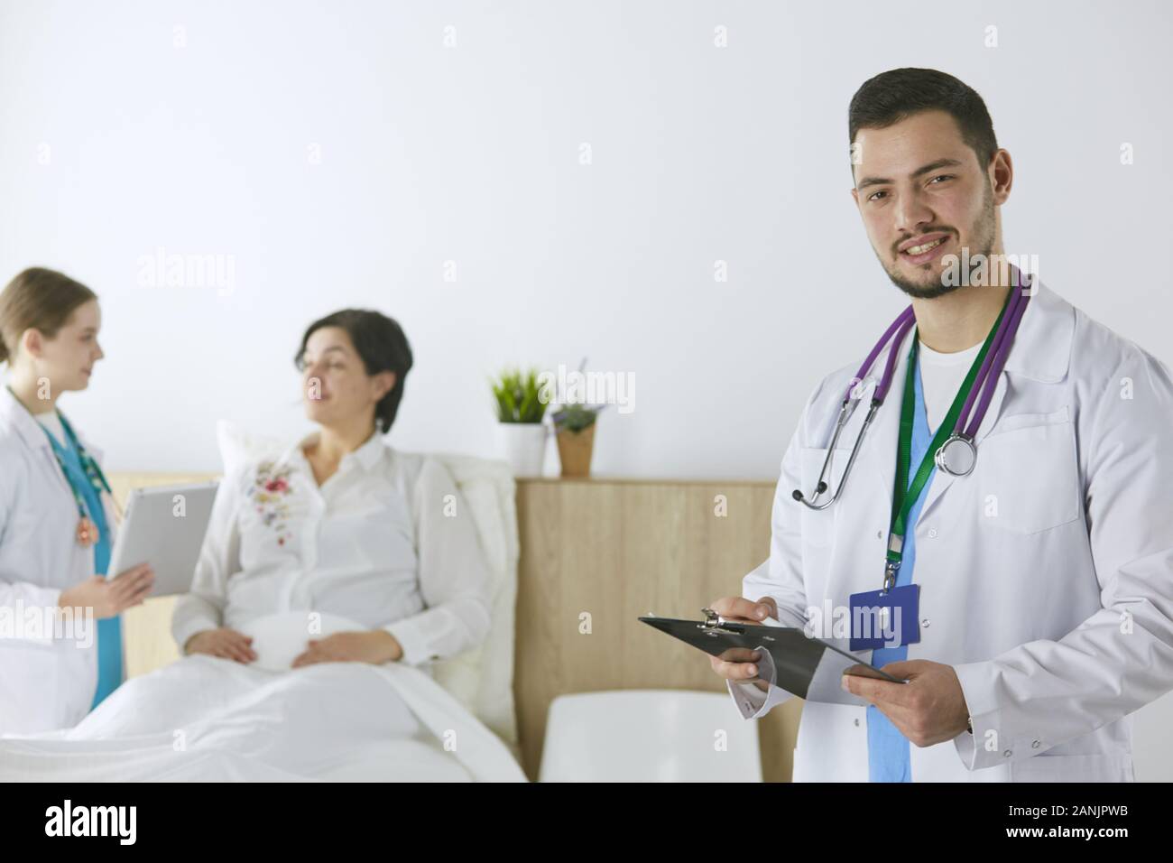 Patient with a group of doctors at the background Stock Photo - Alamy