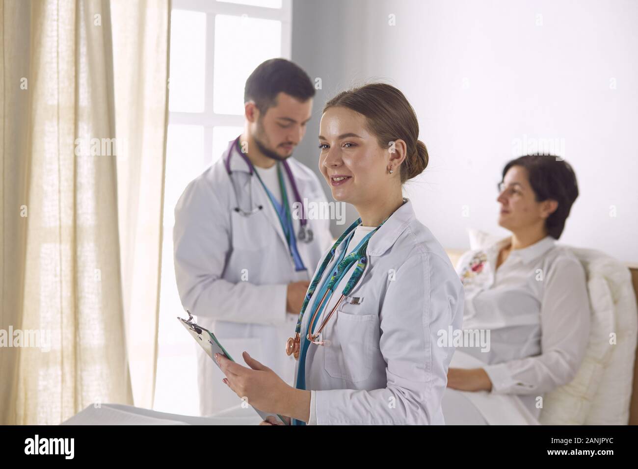 Patient with a group of doctors at the background Stock Photo - Alamy