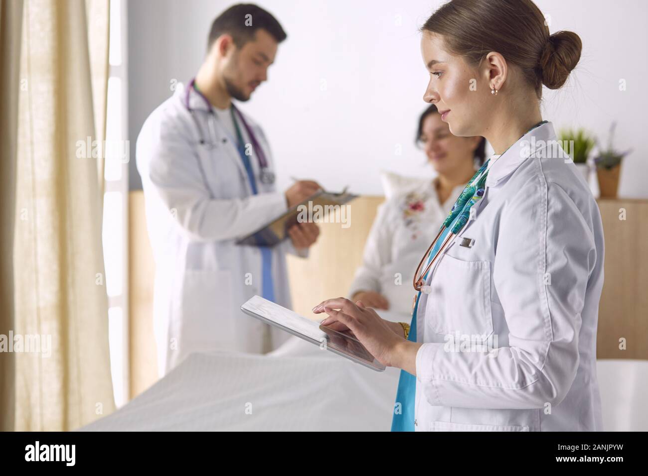 Patient with a group of doctors at the background Stock Photo - Alamy