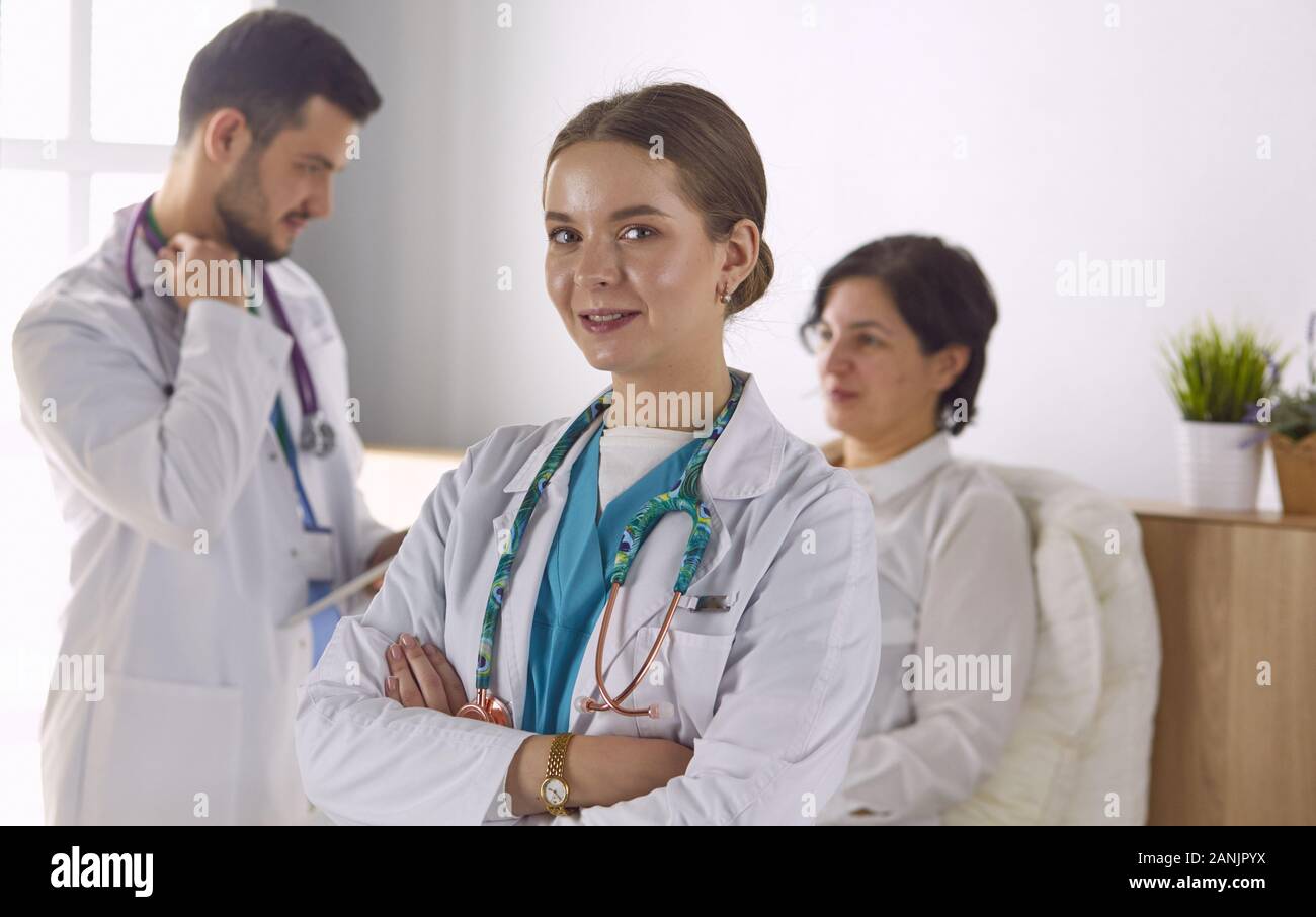 Patient with a group of doctors at the background Stock Photo - Alamy