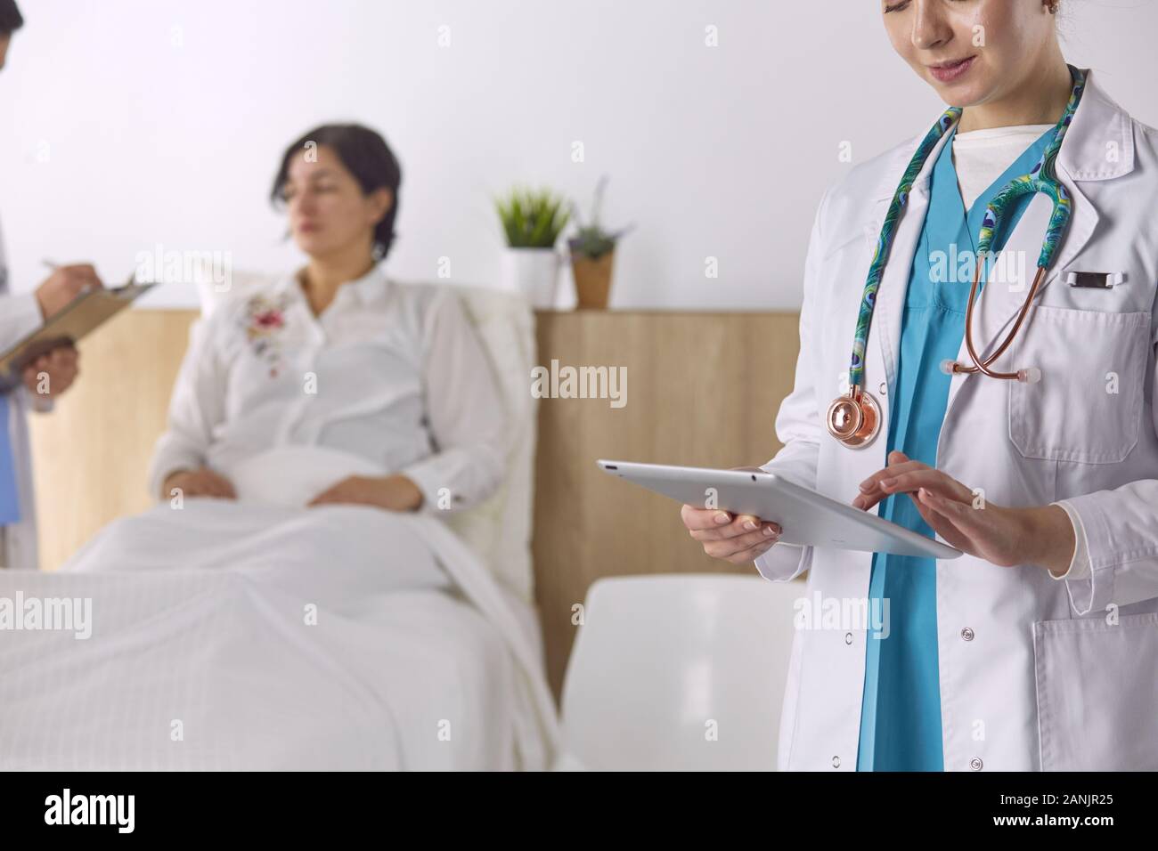 Patient with a group of doctors at the background Stock Photo - Alamy