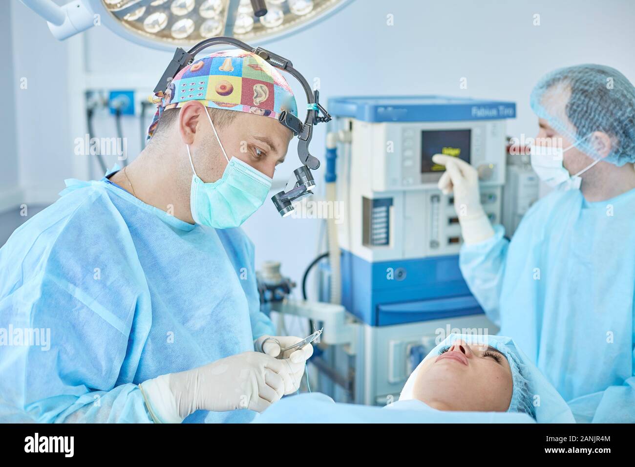 Several doctors surrounding patient on operation table during their ...