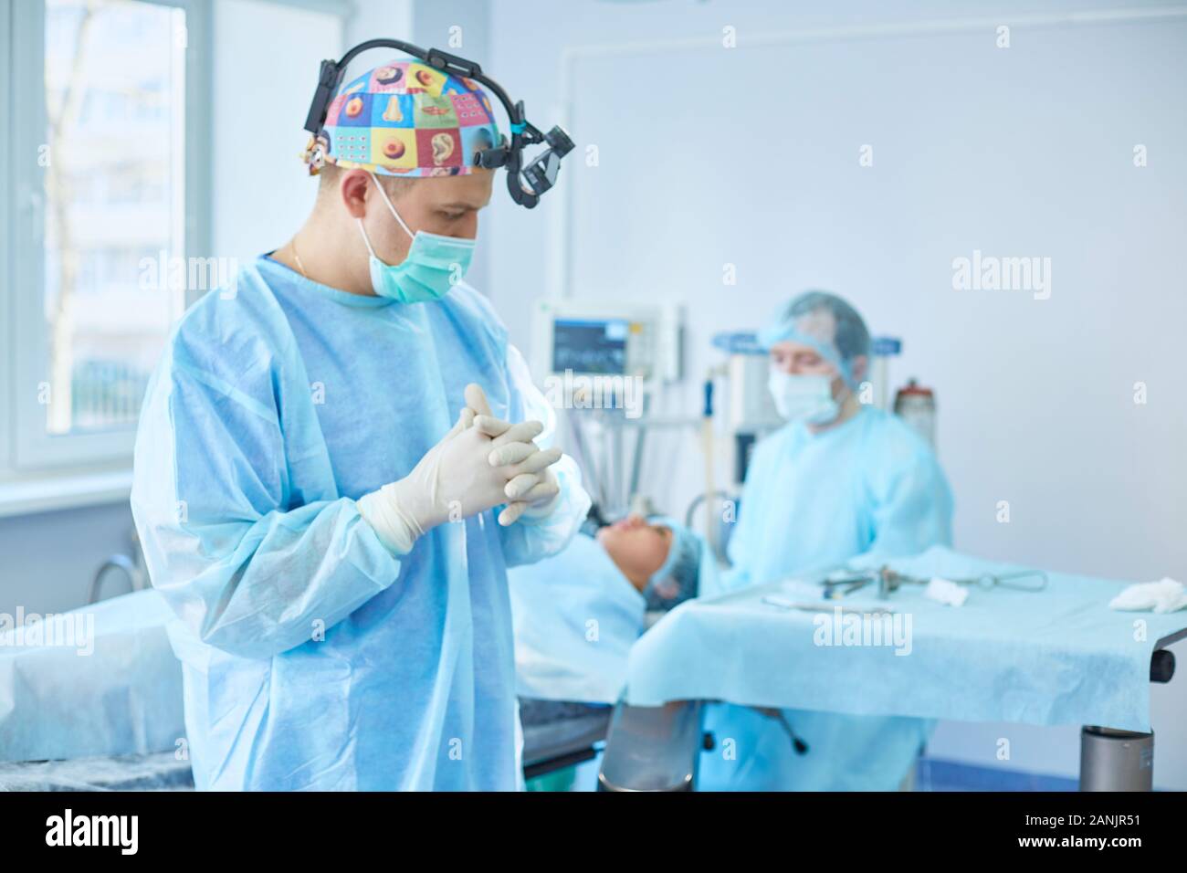 Several doctors surrounding patient on operation table during their ...