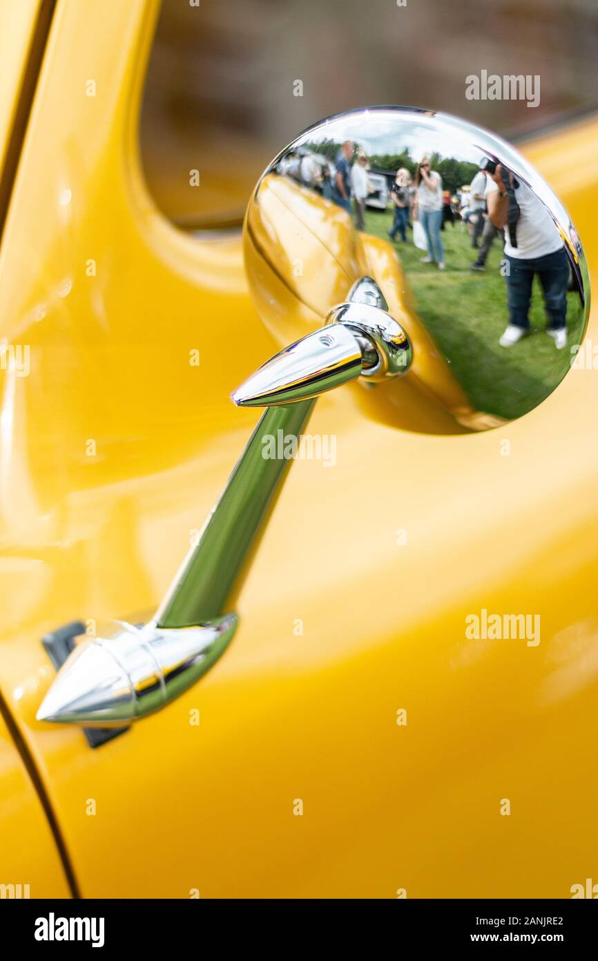 close up of chrome wing mirror on yellow vintage American car at ...