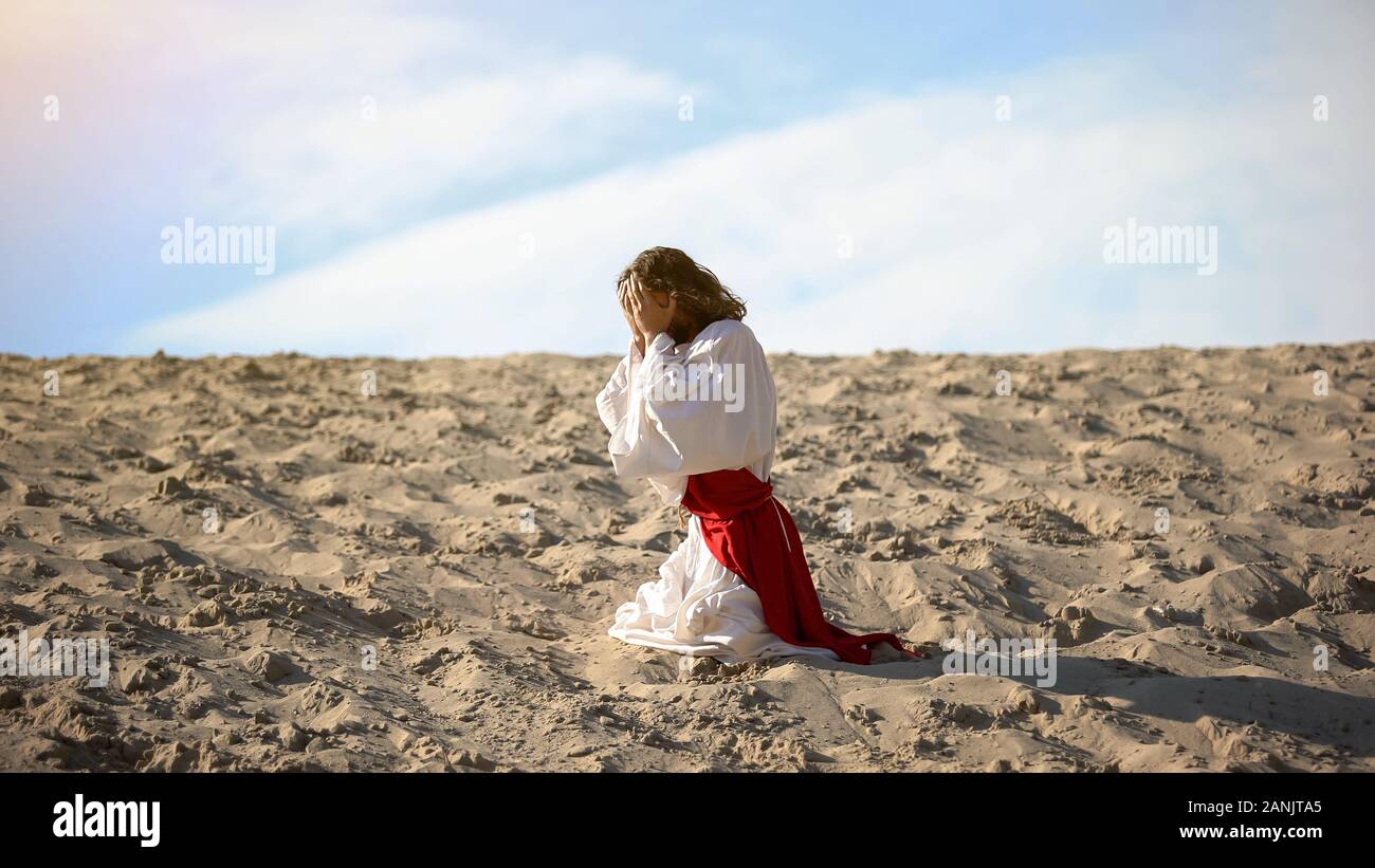 Man in robe repenting for sins, praying to God in desert, pangs of ...