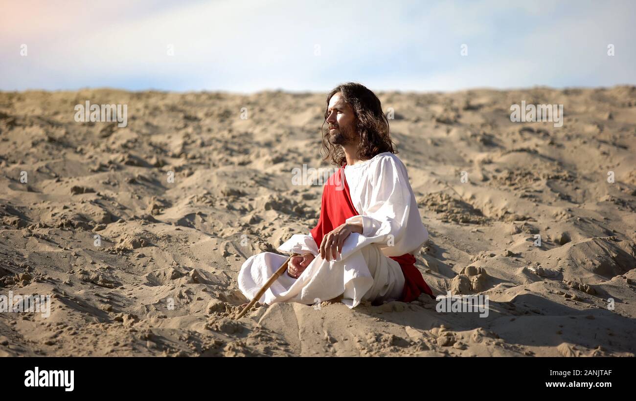 Pastor In white robe sitting in lotus pose in desert, peaceful mind ...