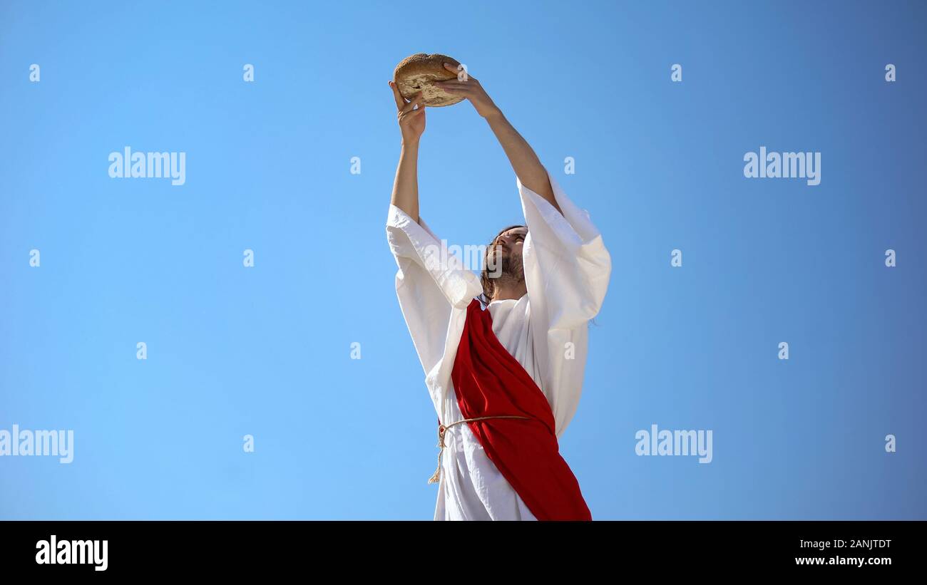 Jesus God raising bread in hands to sky, blessing sacramental food ...