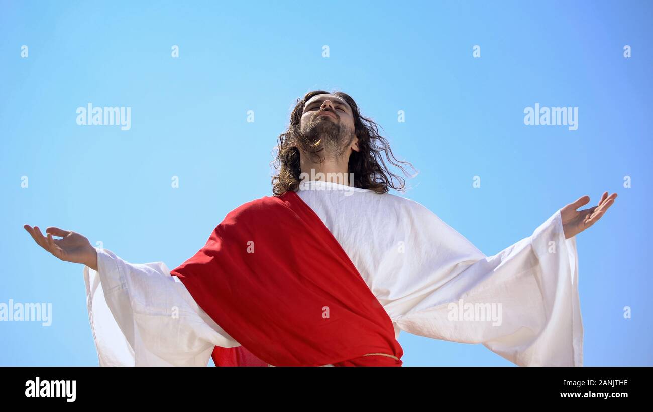 Saint man in robe raising hands to sky, praying for soul salvation ...