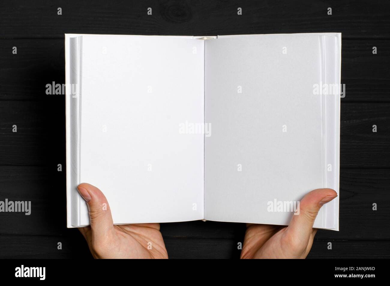 Men's hands hold a white book with clean pages Stock Photo - Alamy