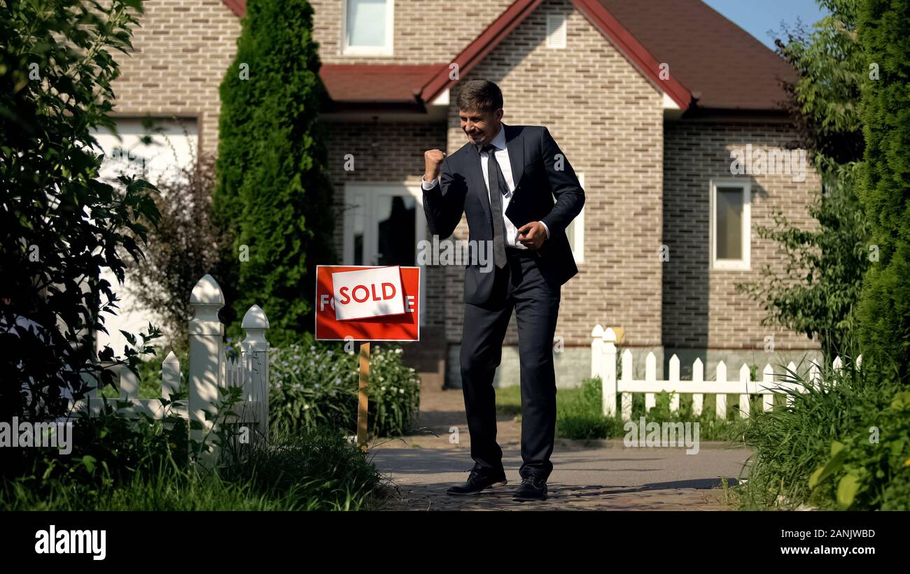 Estate agent in business suit showing yes gesture standing in front of ...