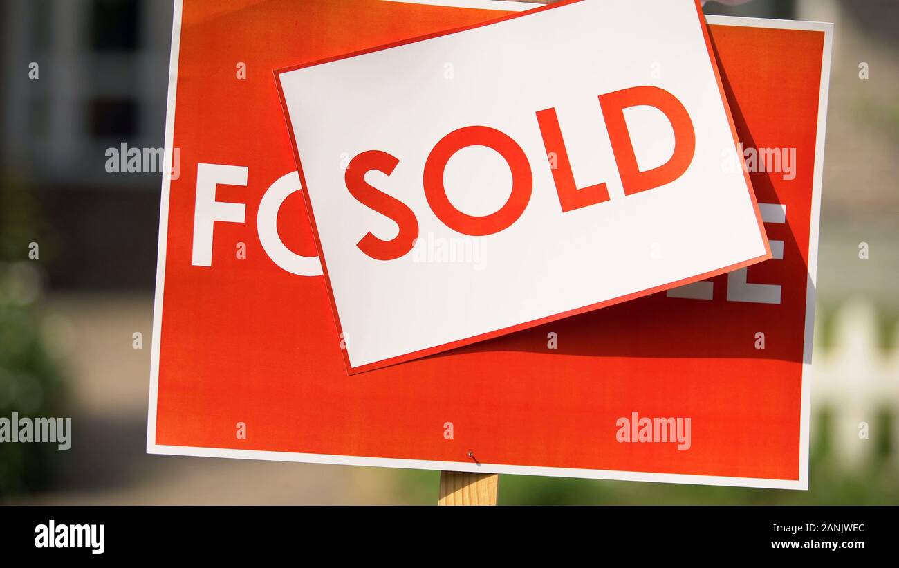Close-up sold paper installing on for sale signboard, real estate ...