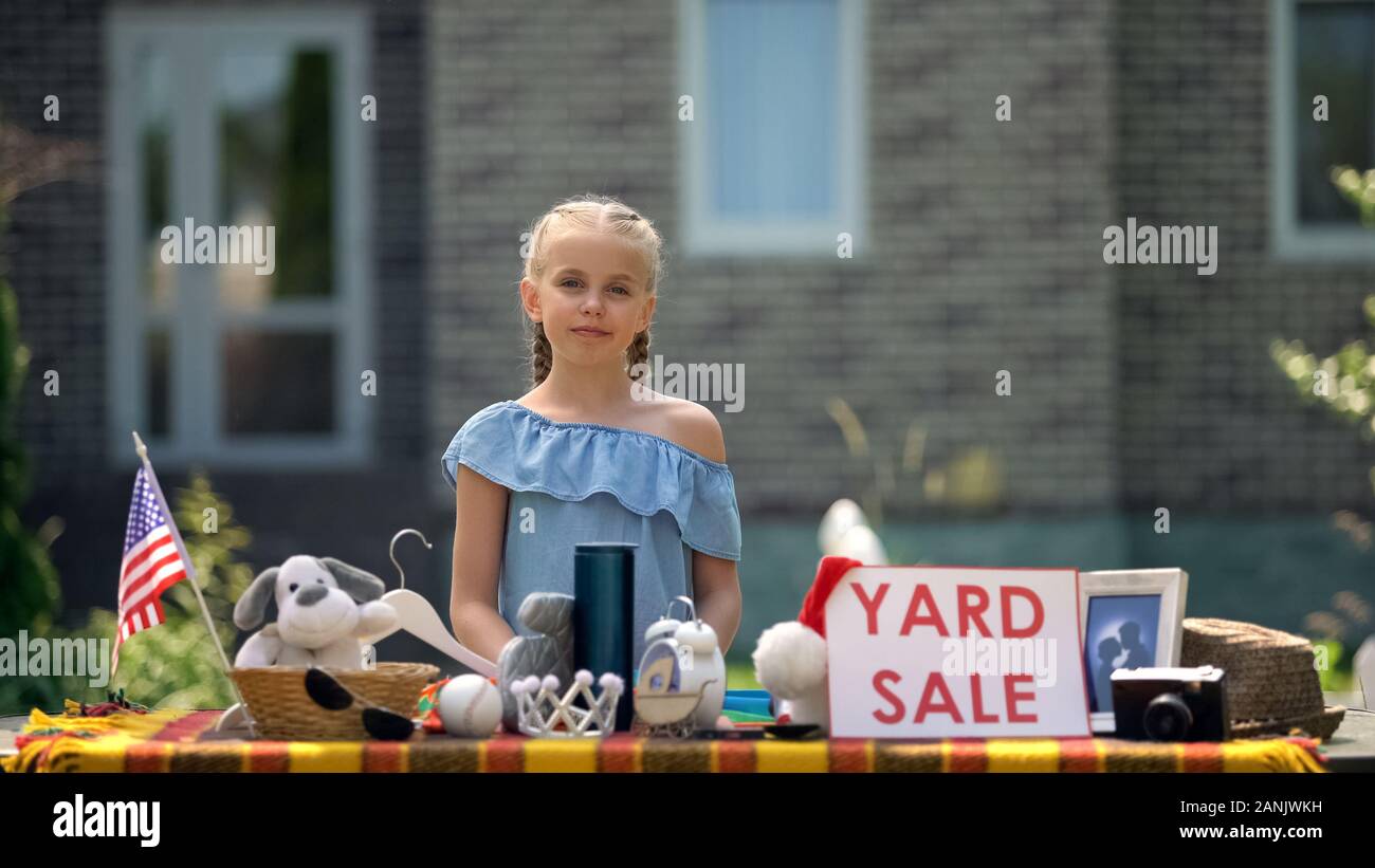 Young business lady selling old toys on yard sale, earning extra pocket ...