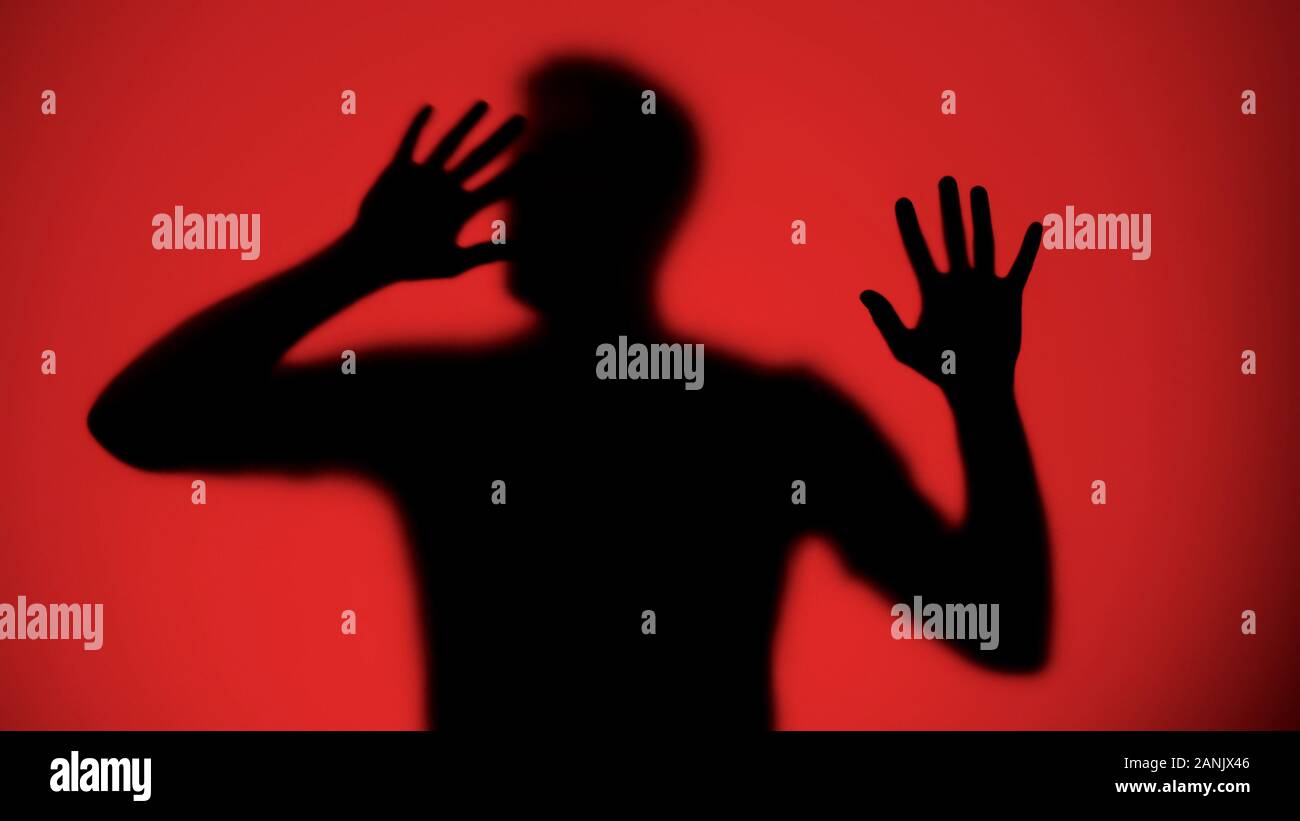 Desperate male silhouette trying to escape from captivity, red ...