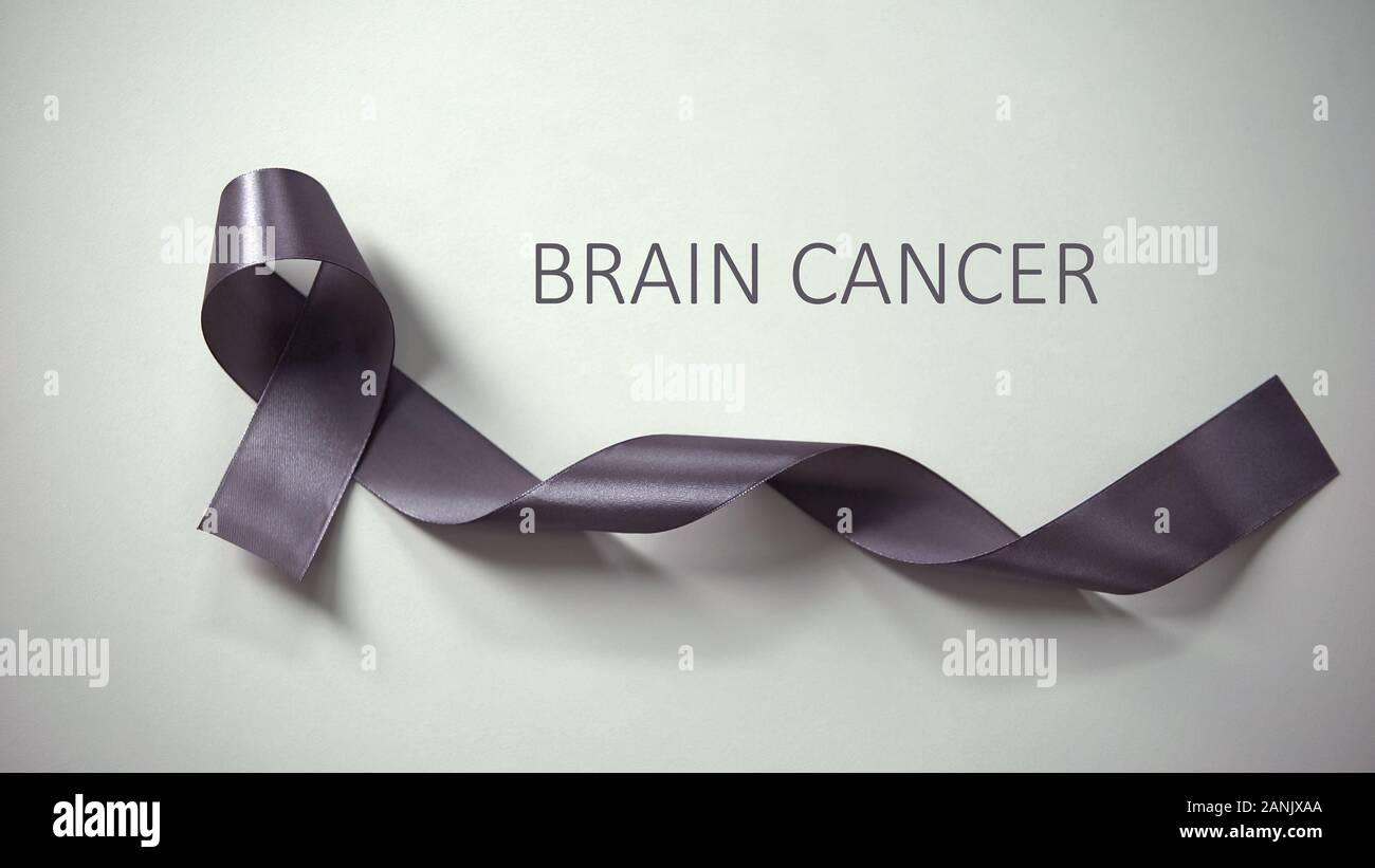 Brain cancer inscription, gray ribbon lying on table, awareness ...