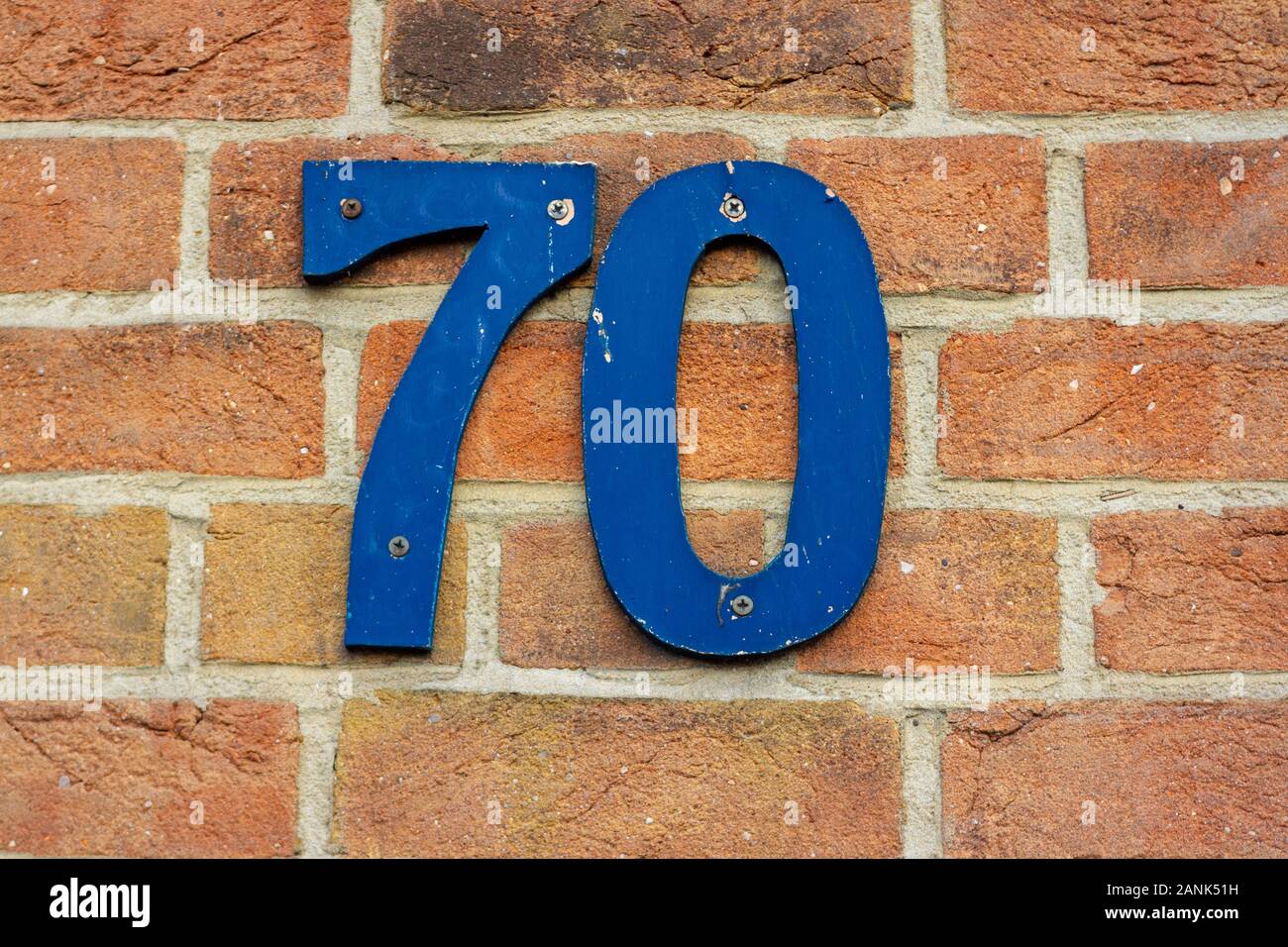 Blue house number 70 on a red brick wall Stock Photo - Alamy