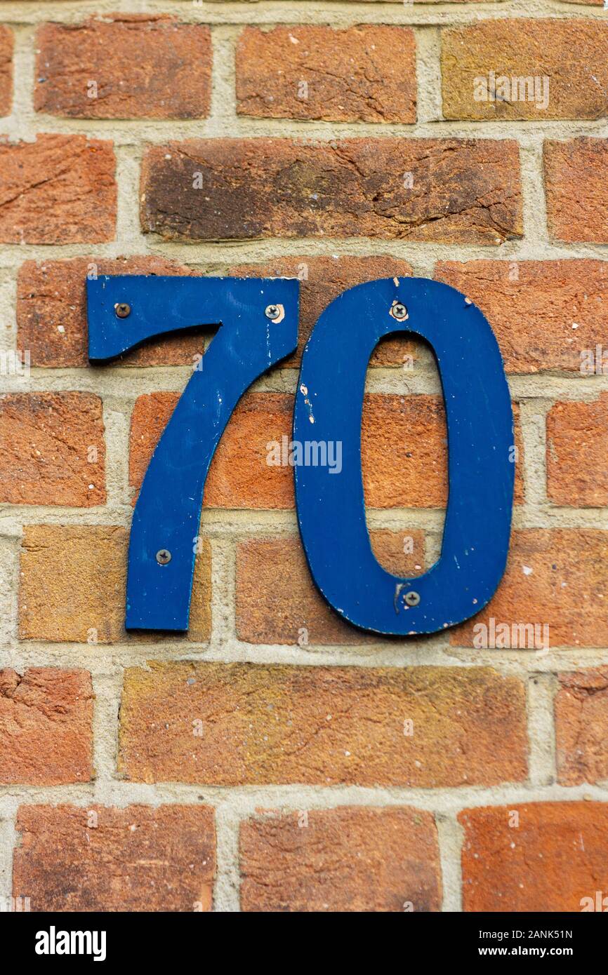Blue house number 70 on a red brick wall Stock Photo - Alamy