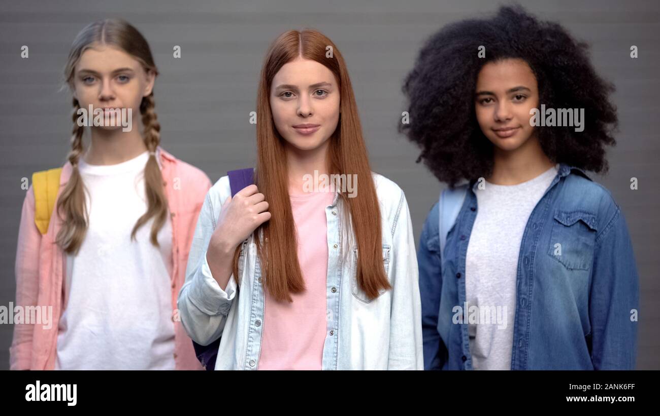 Multiethnic group of female students looking camera grey background ...