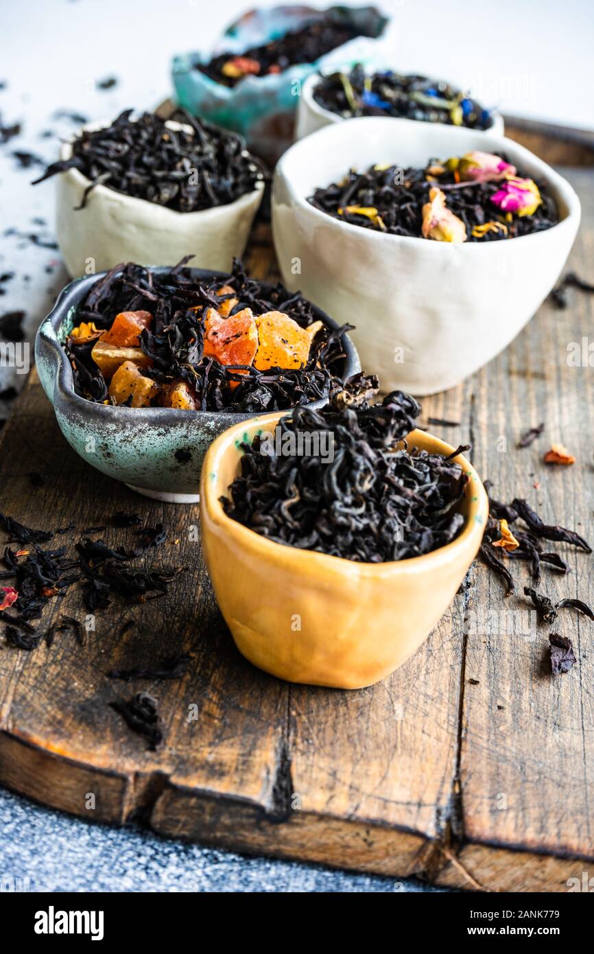 Different tea varieties in ceramic bowls on stone rustic background ...