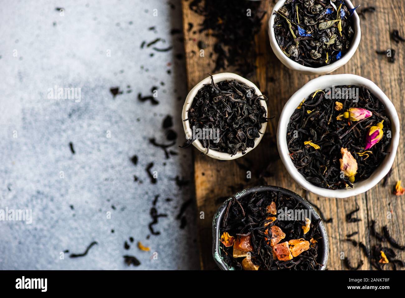 Different tea varieties in ceramic bowls on stone rustic background ...