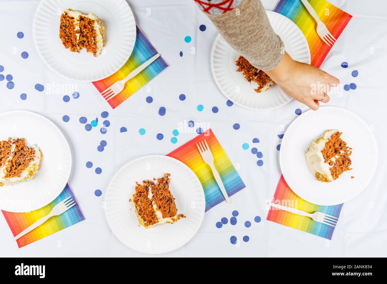 Flat lay with birthday cake pieces on white paper plates. Birthday ...