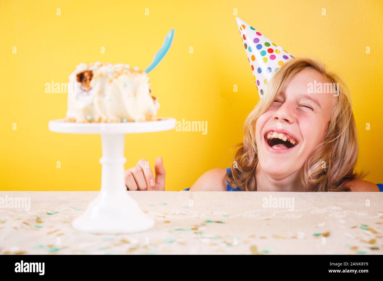 Teenage girl enjoying herself after ruining birthday cake. One person ...