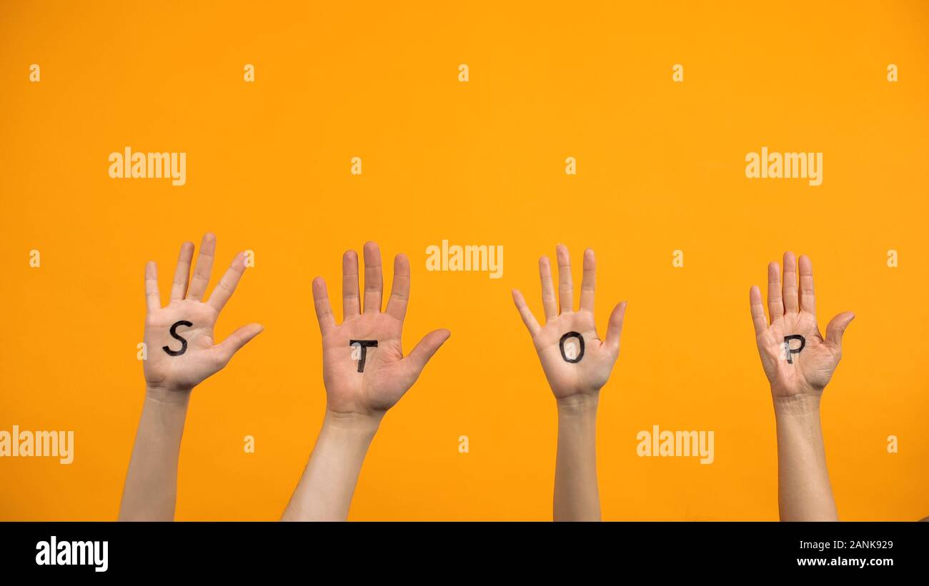 Stop written palms on orange background, danger warning, protest ...