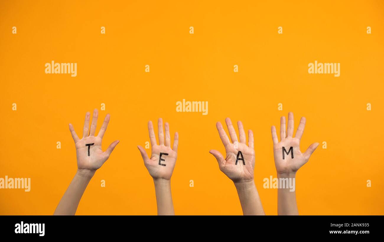 Team written palms on orange background, unity cooperation, group ...