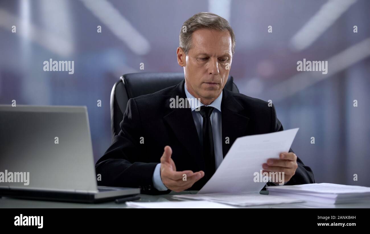 Boss checking reports, finding mistake in important contract ...