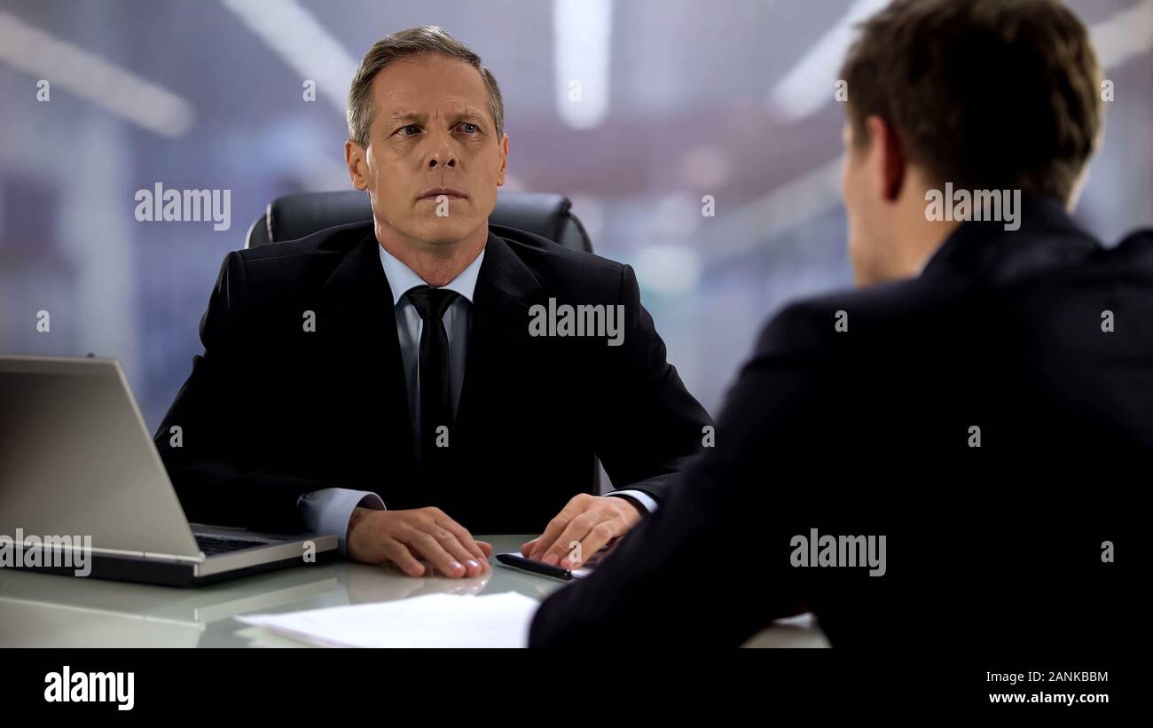 Male boss listening to employer in office, discussing important ...