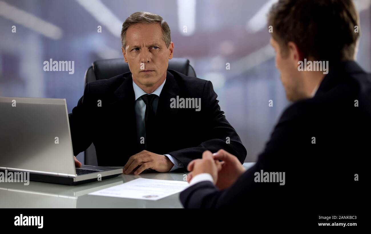 Angry boss looking at candidate, failed job interview, cv lying on ...