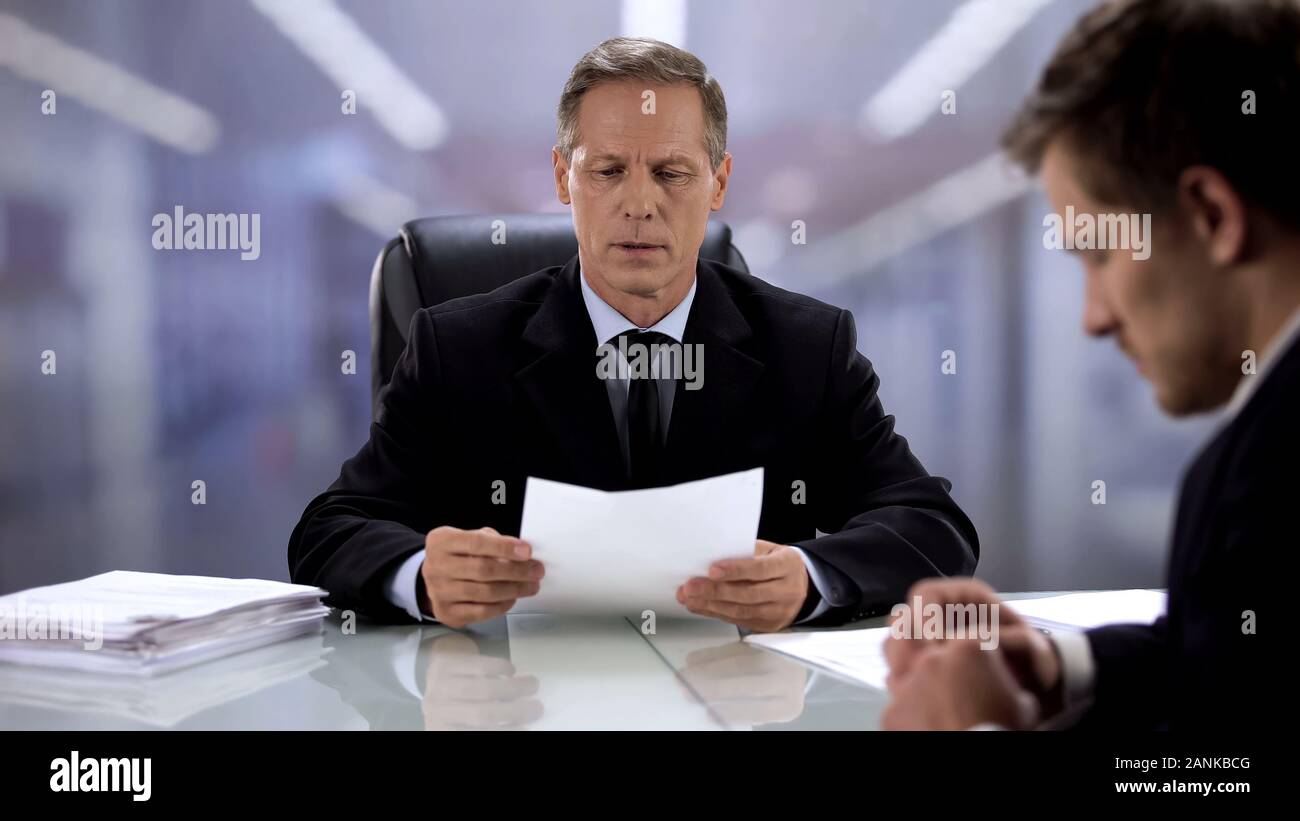 Nervous candidate waiting for employer reading curriculum vitae, hoping ...