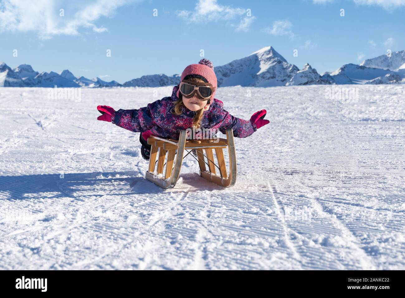 Cheerful Little Girl Sliding With Sledge In The Snow At Laax Stock ...
