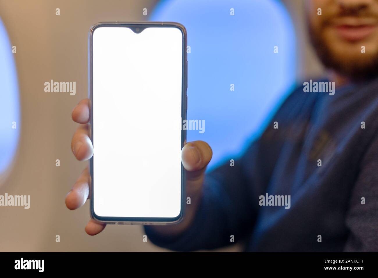 Mockup smartphone airplane. Young attractive european man holding blank ...