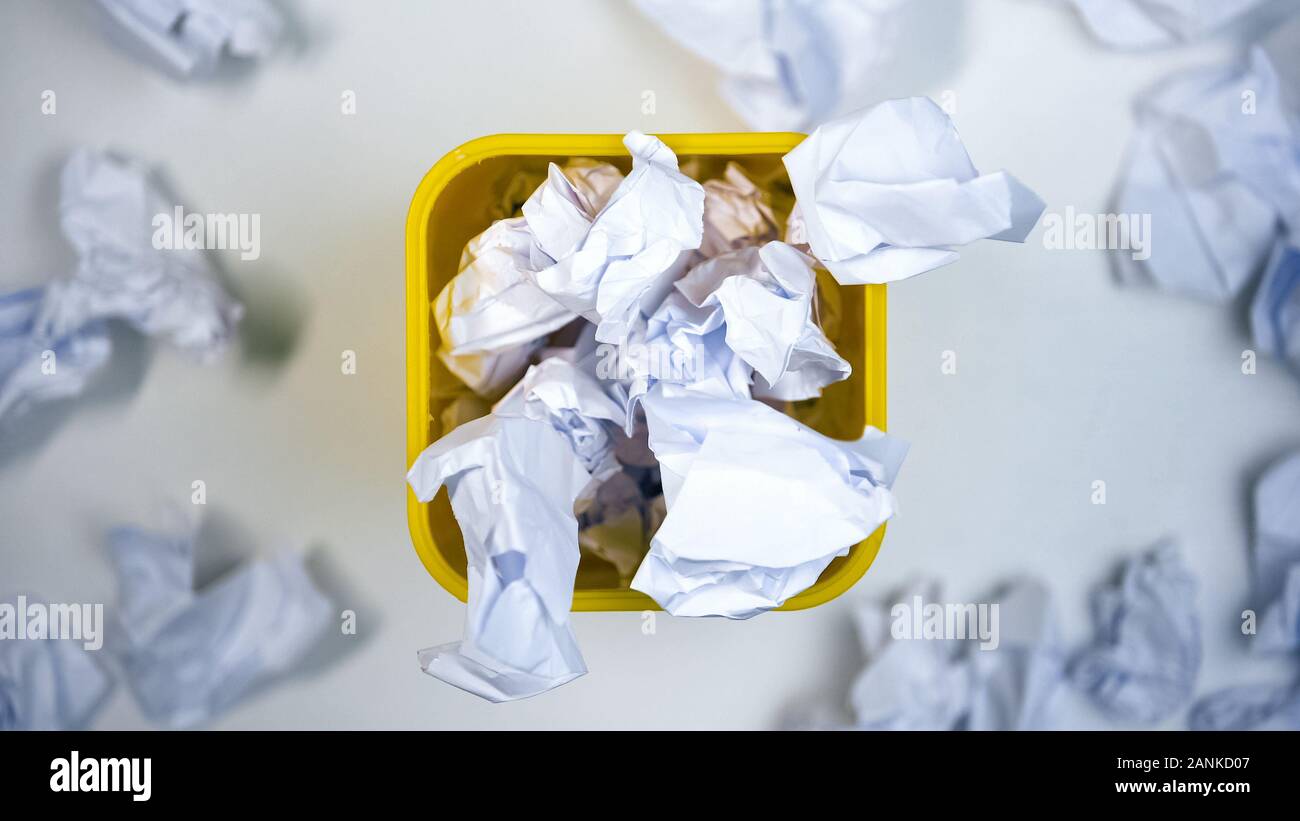 Yellow bin full of crumpled paper, waste material pollution, recycling ...