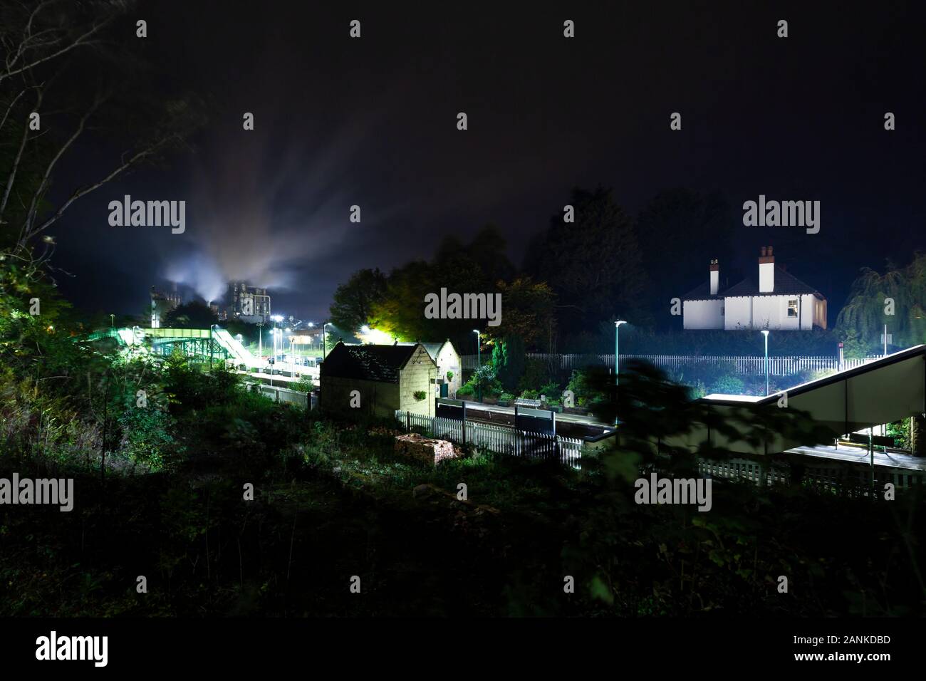 A night scene of Chirk railway station with clouds of steam and smoke ...