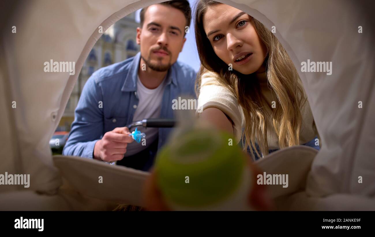 Inexperienced parents trying to calm crying baby in carriage, lack of ...