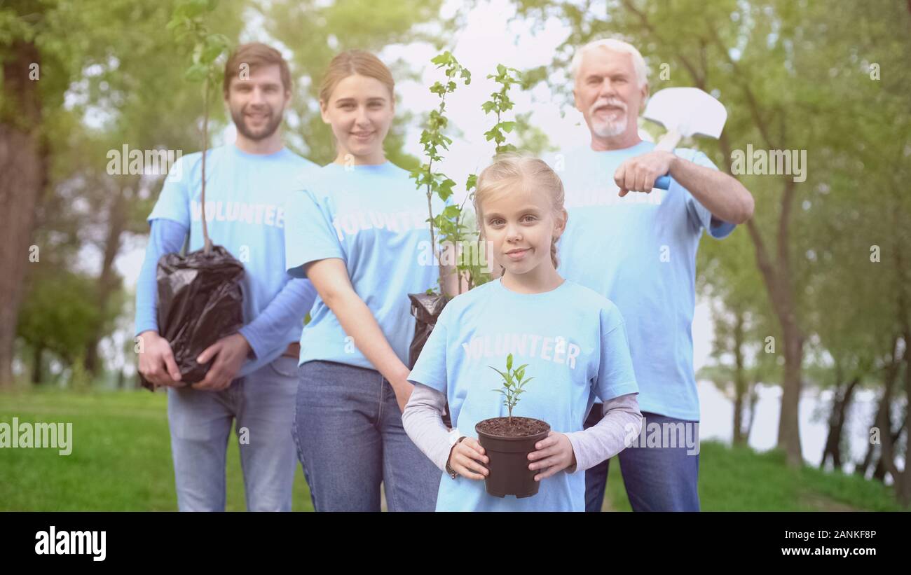 Group of volunteers holding trees saplings and shovel, nature ...