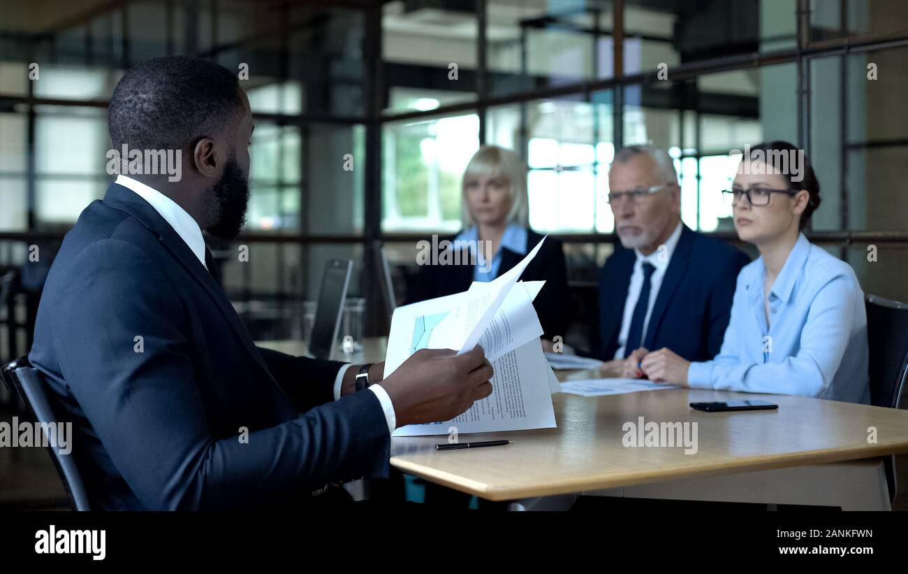 Strict afro-american businessman looking colleagues, strained business ...