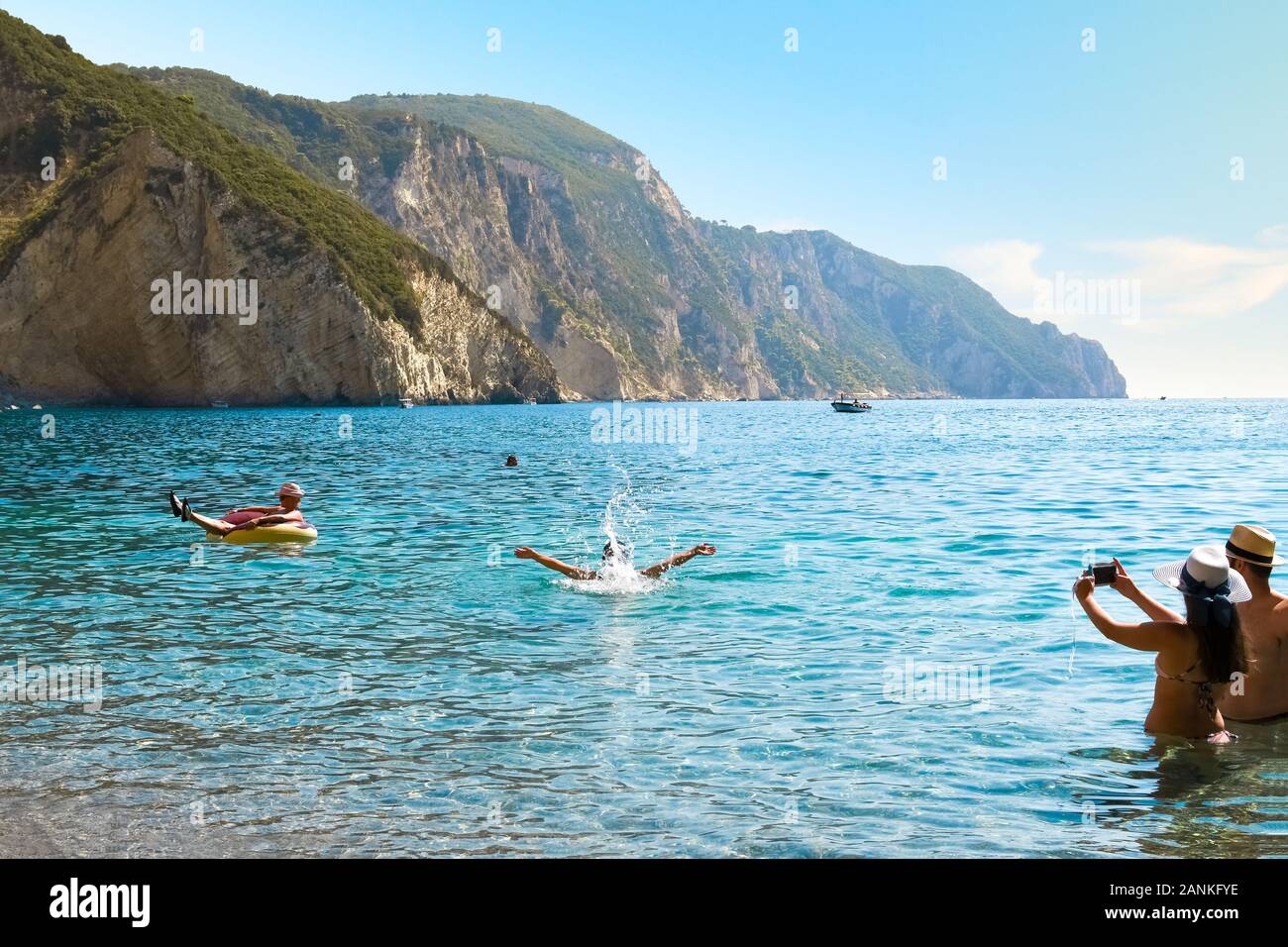 Tourists play in the sea at Chomi or Paradise Beach on the Greek Island ...