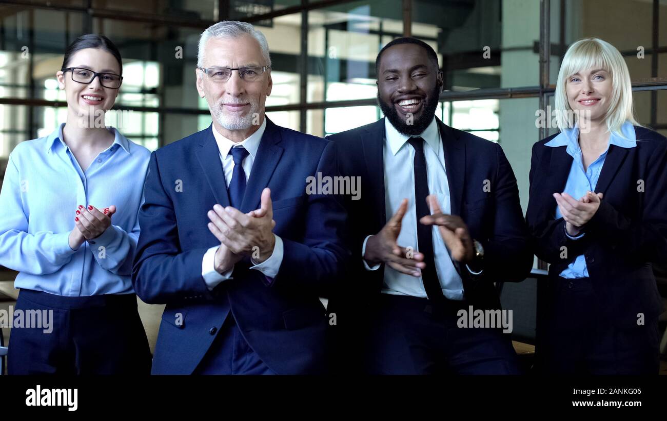 Multiethnic group of business people applauding looking camera ...