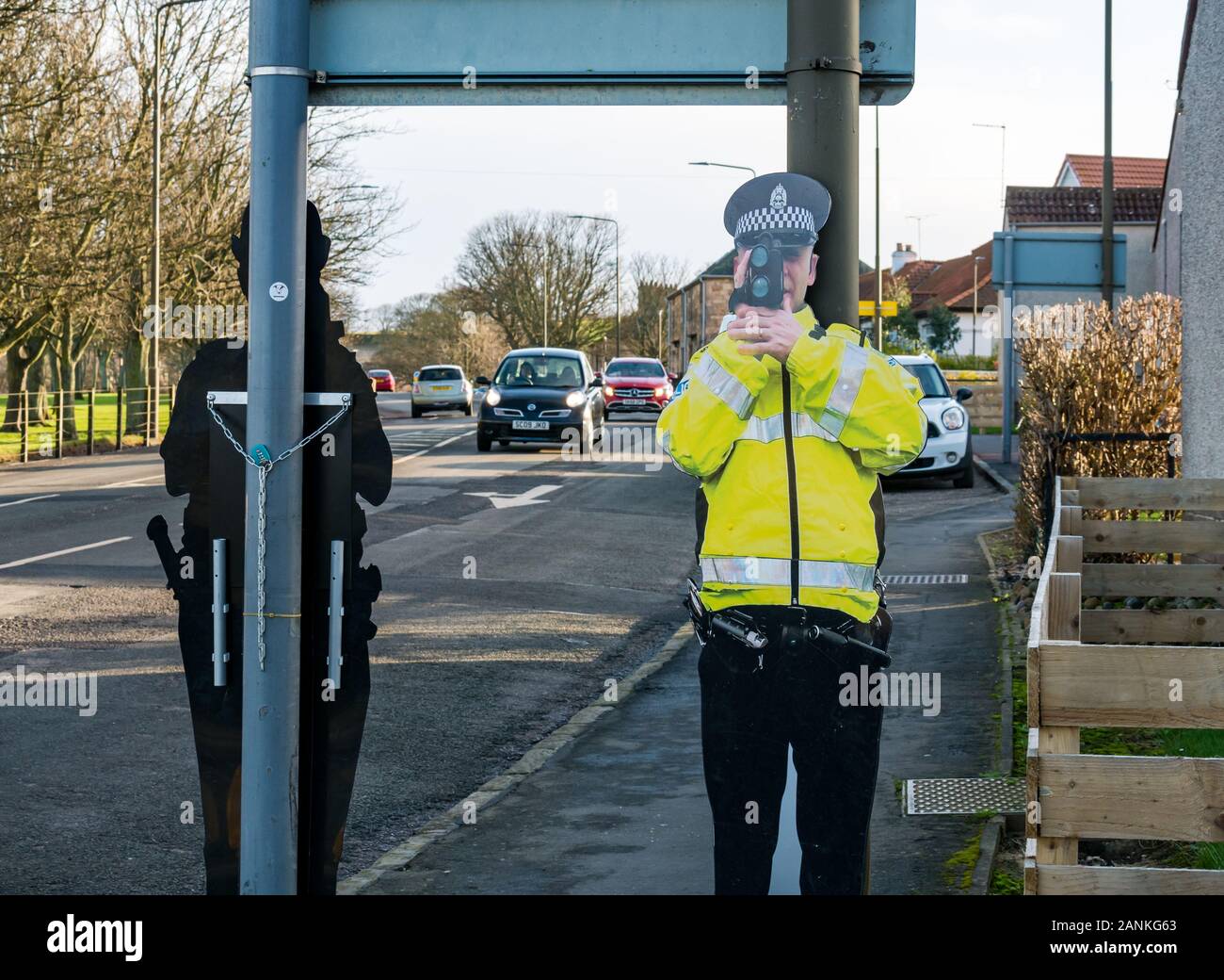 Cardboard cut-out of traffic policeman with speed camera at roadside ...
